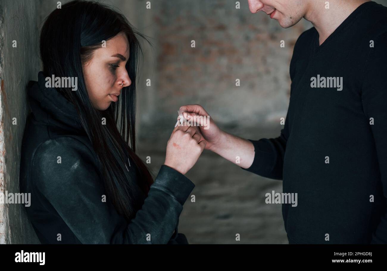 Two people standing with illegal drugs in little package indoors Stock ...