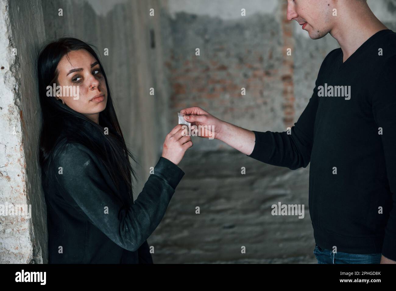 Two people standing with illegal drugs in little package indoors Stock ...