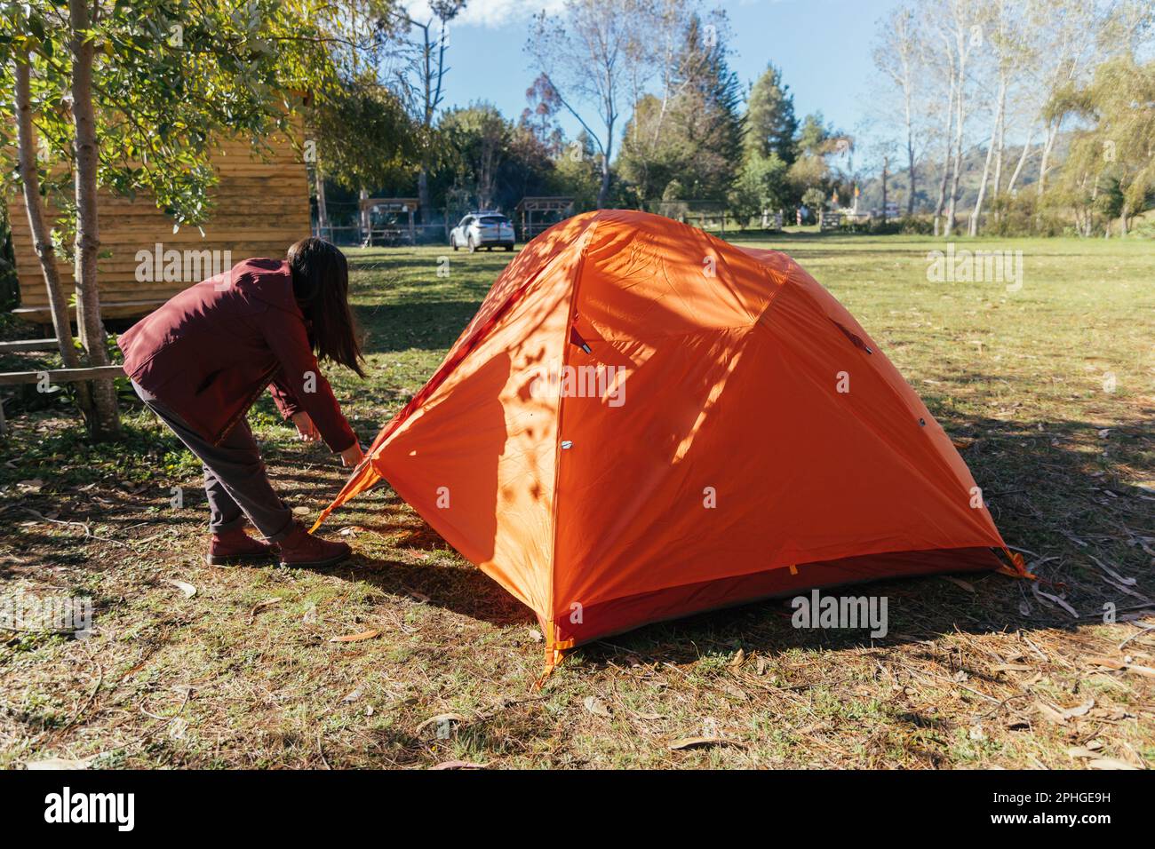 Tourist woman opening orange camping tent from outside Stock Photo - Alamy