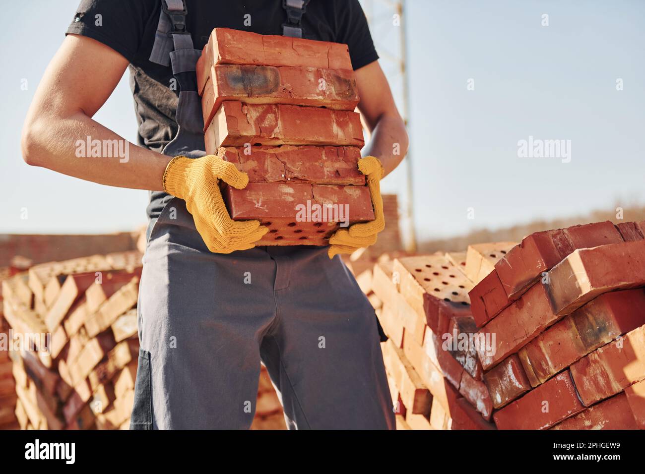 Installing brick wall. Construction worker in uniform and safety ...