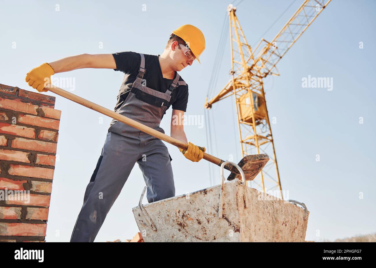 Using showel. Construction worker in uniform and safety equipment have ...