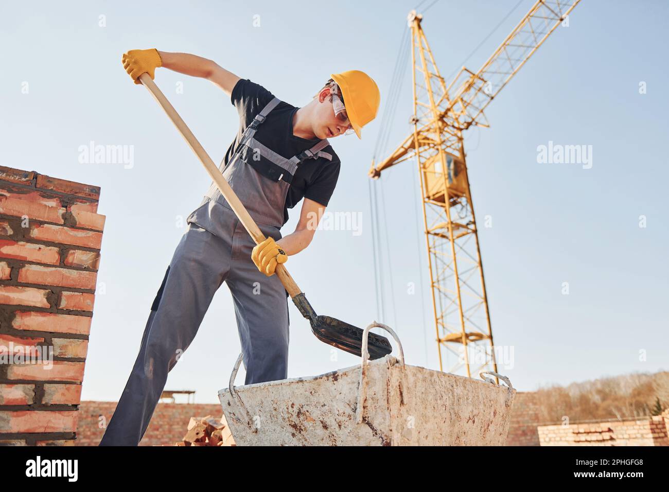 Using showel. Construction worker in uniform and safety equipment have ...