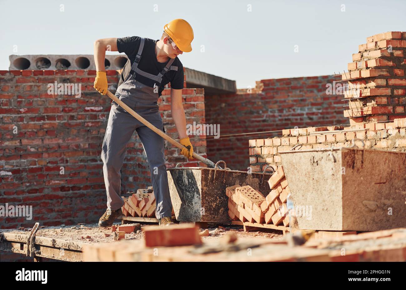 Using showel. Construction worker in uniform and safety equipment have ...