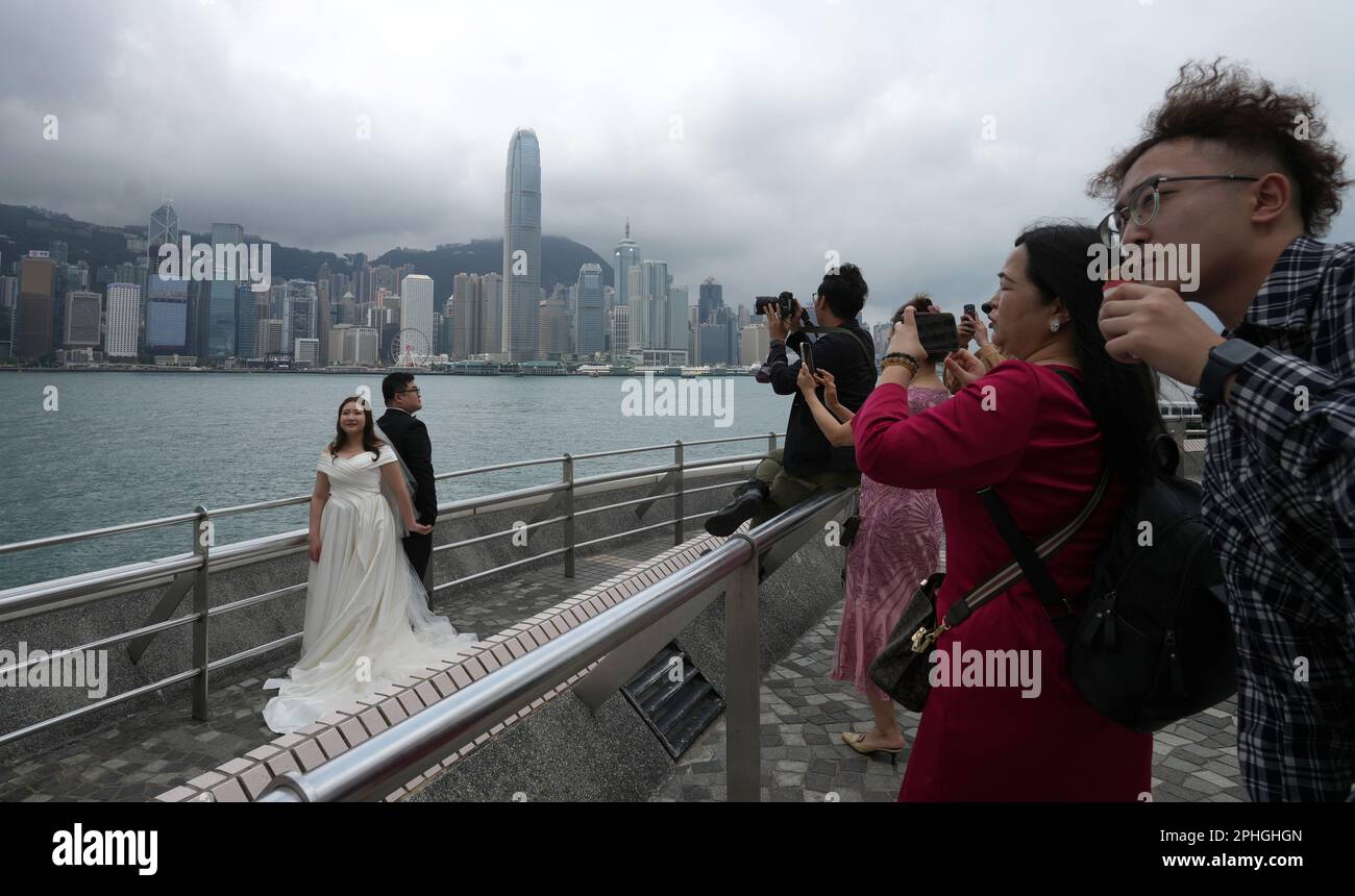 A bride and groom poses for pictures at the waterfront of Victoria ...