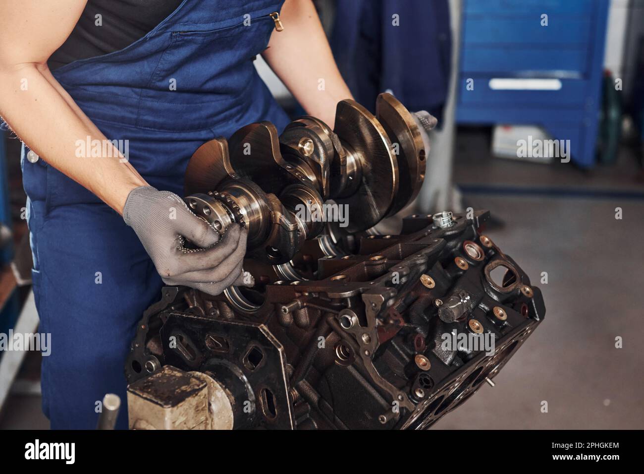 Professional repairman in garage works with broken automobile engine ...