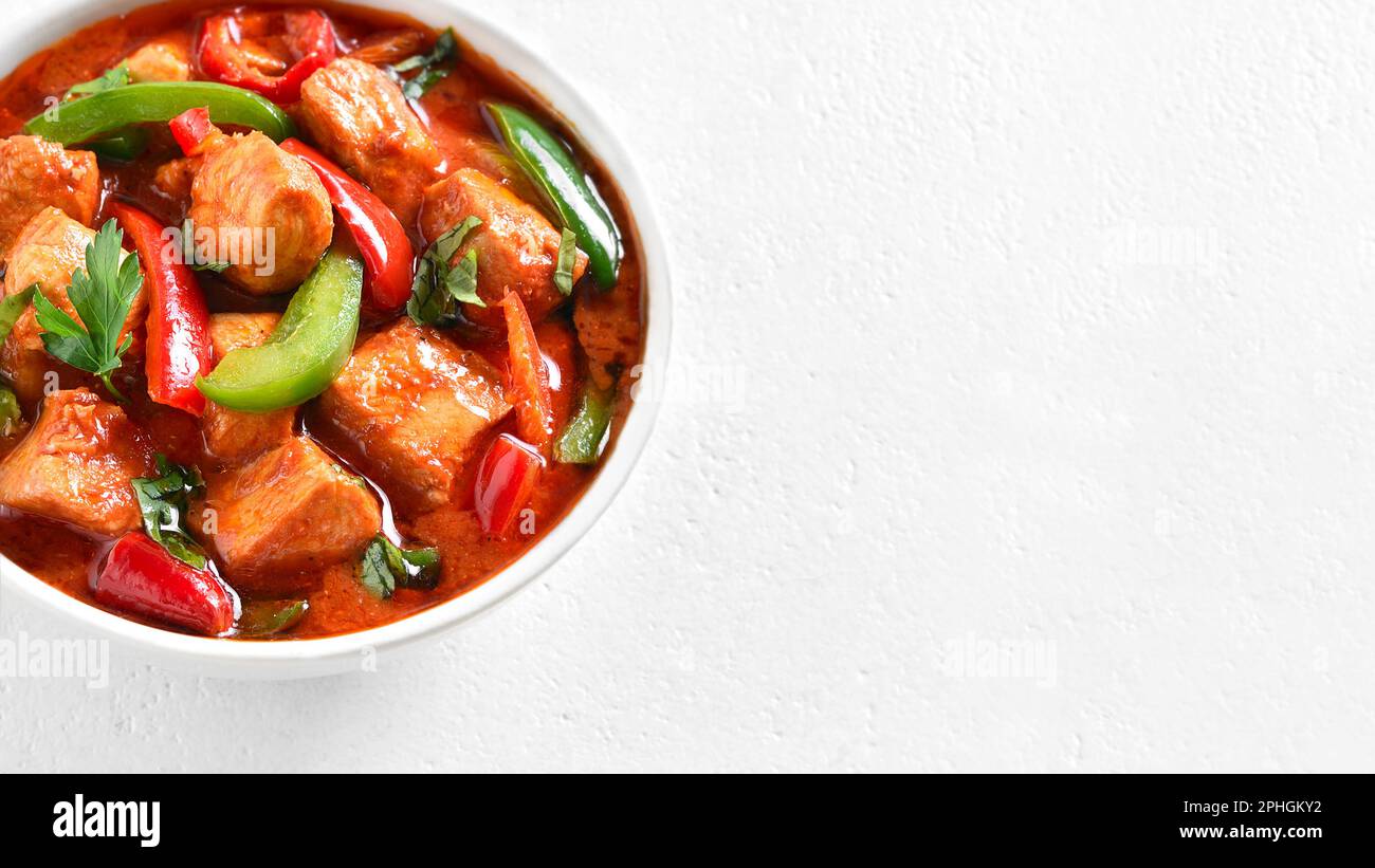 Close up view of thai style red chicken curry with vegetables in bowl ...