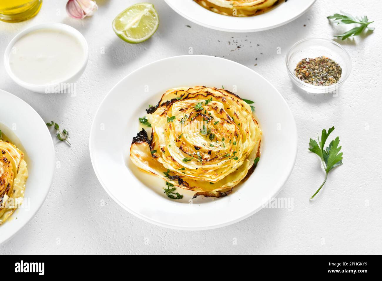 Roasted cabbage steaks on plate over white background Stock Photo - Alamy