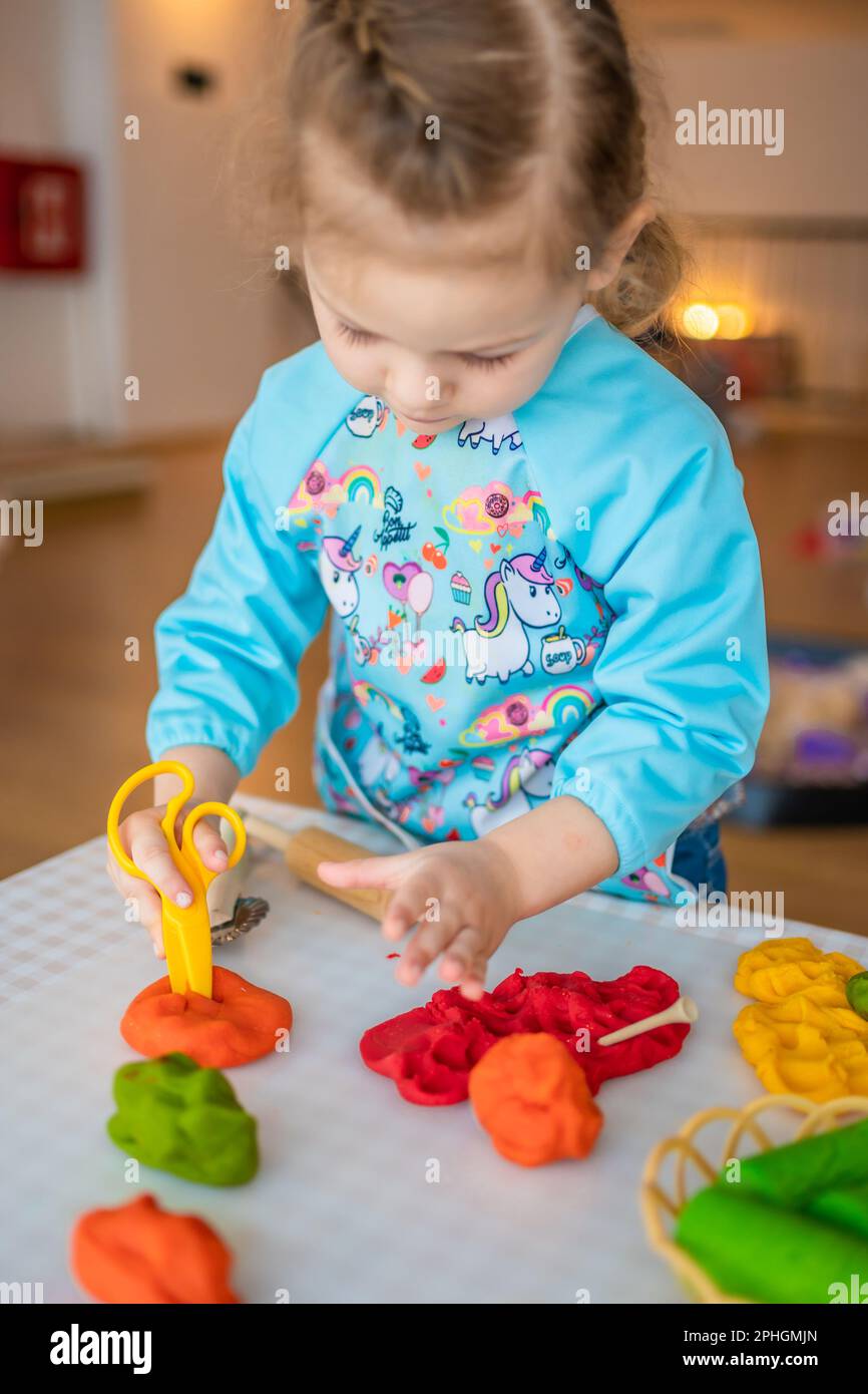 A little girl playing with plasticine. Sensory development and ...