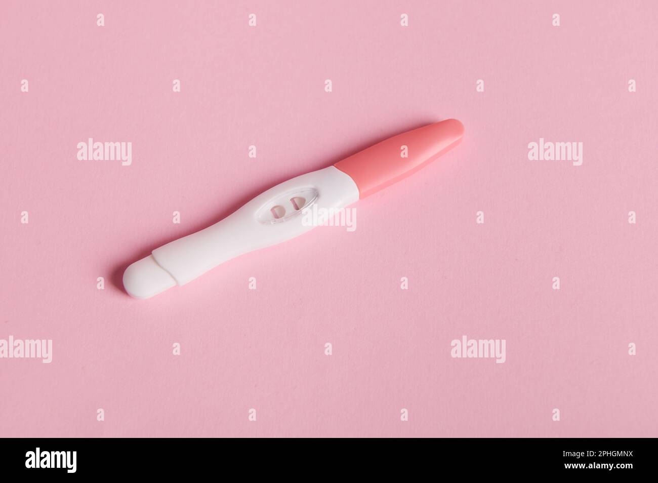 Positive inkjet pregnancy test kit on pink color background. Rapid ...
