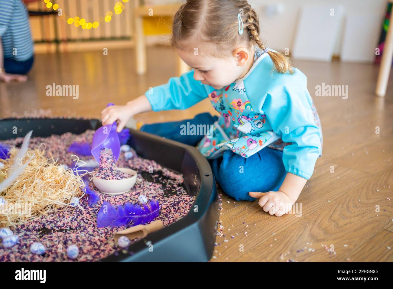 Little girl playing with sensory colorful rice. Sensory development and ...