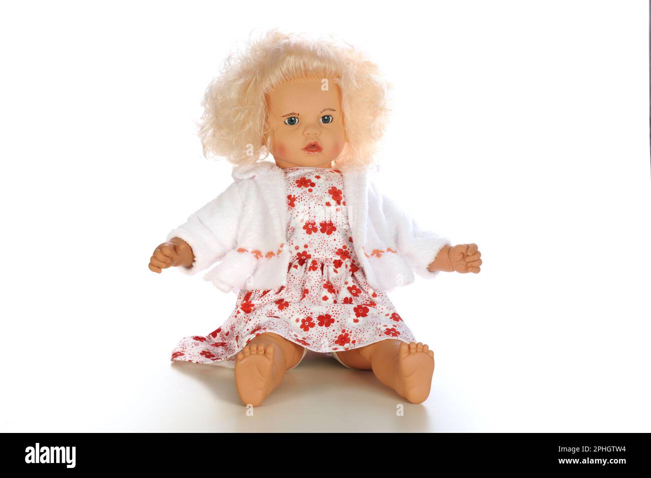 A doll in a white dress with red polka dots. on a white background ...