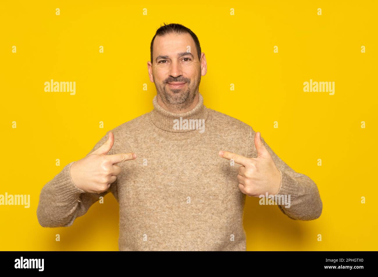 The portrait of a bearded handsome man points to himself puzzled at ...