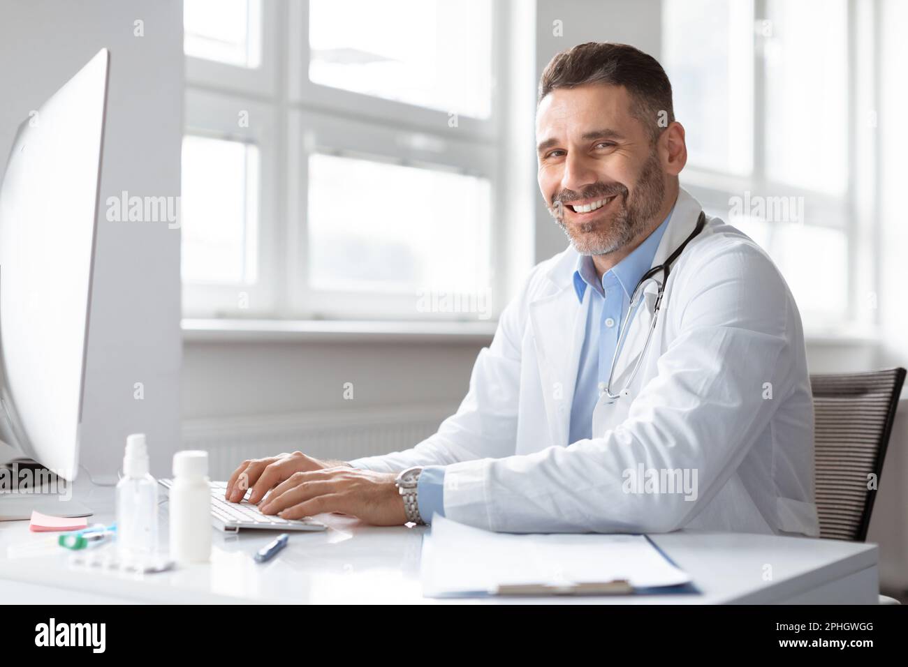 Happy male doctor medic expert using computer at work in hospital ...