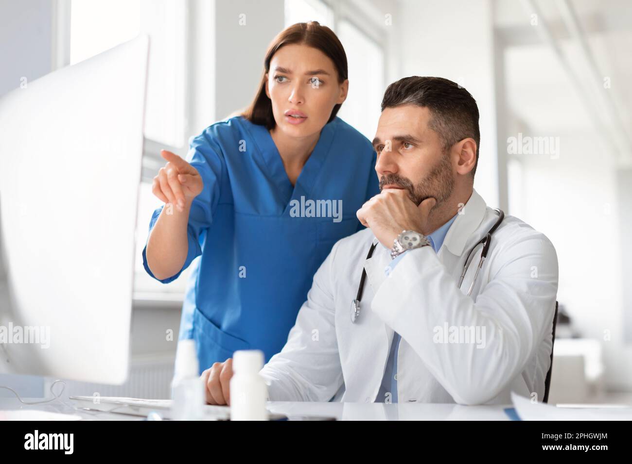 Two doctors talking and using computer, discussing diagnose and tests ...