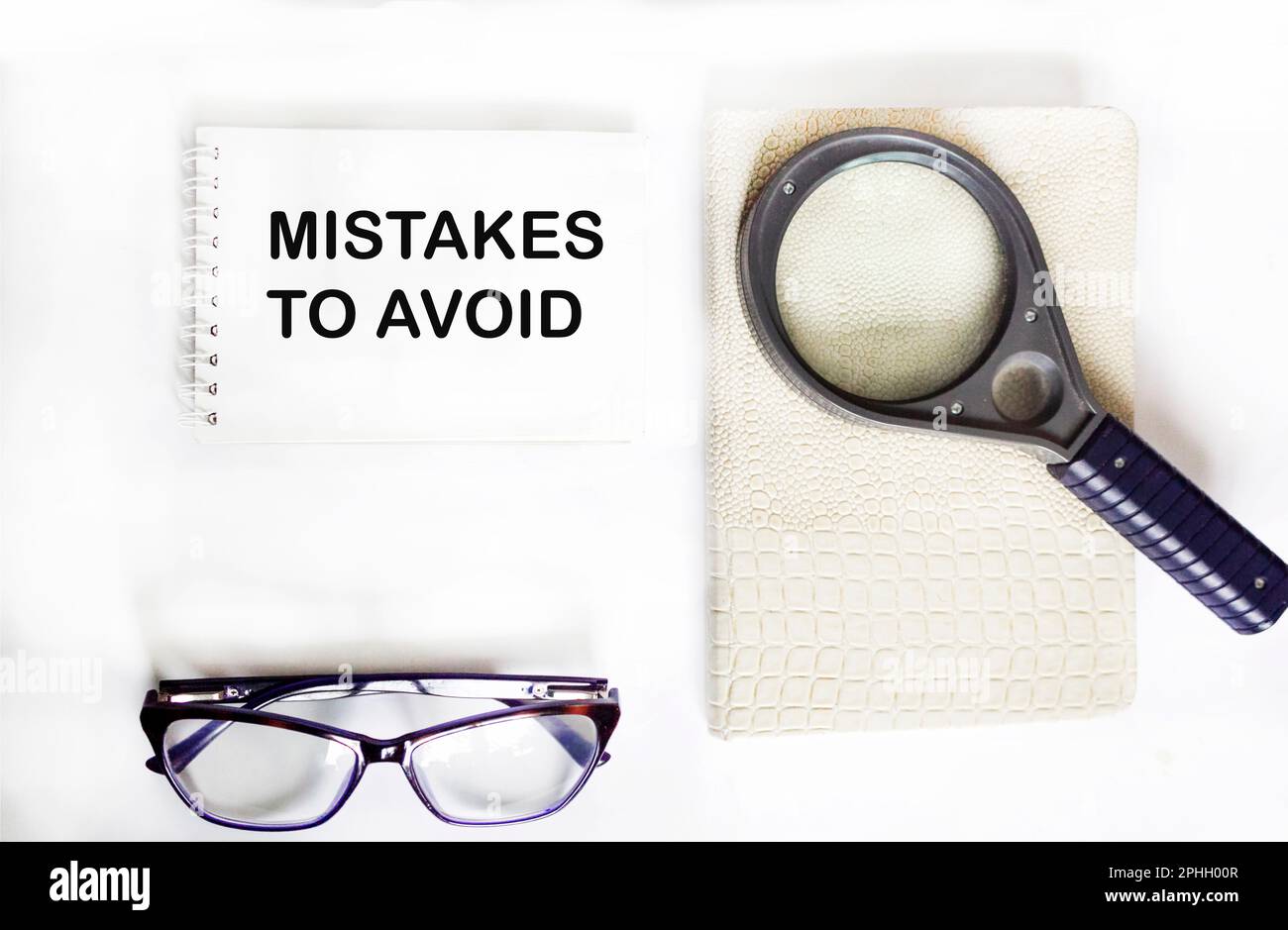 Notepad with the text Mistakes to avoid lies on a white background with ... Notepad with the text Mistakes to avoid lies on a white background with ...