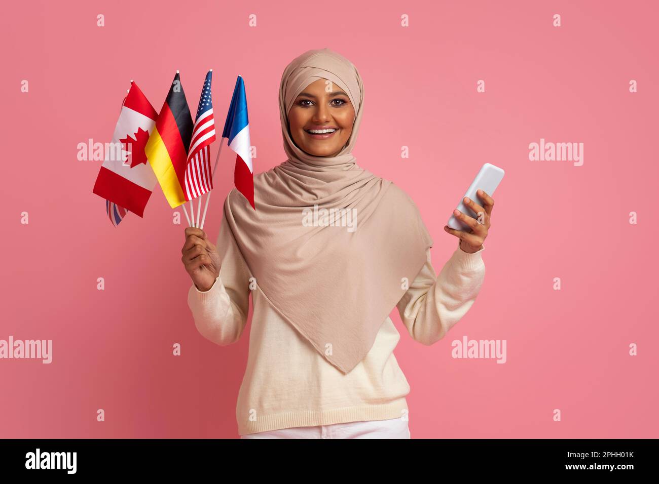 Online Translator App. Smiling Muslim Woman Holding International Flags ...