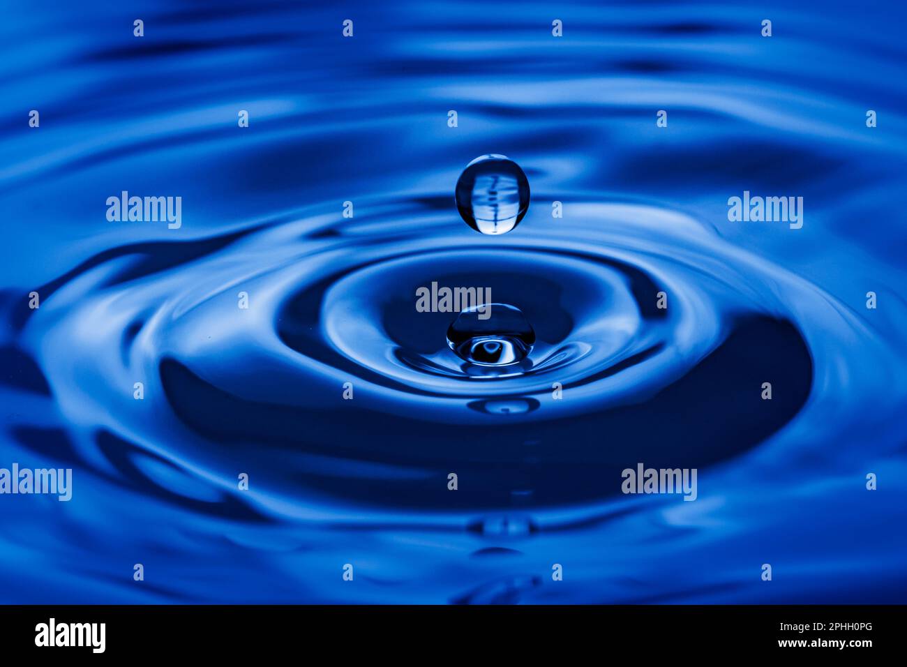 A single drop of water falling into a vibrant blue swimming pool Stock ...