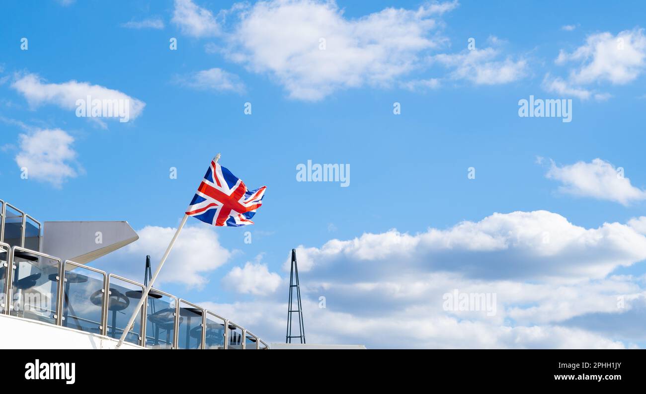 britain flag waving in blue sky background Stock Photo - Alamy