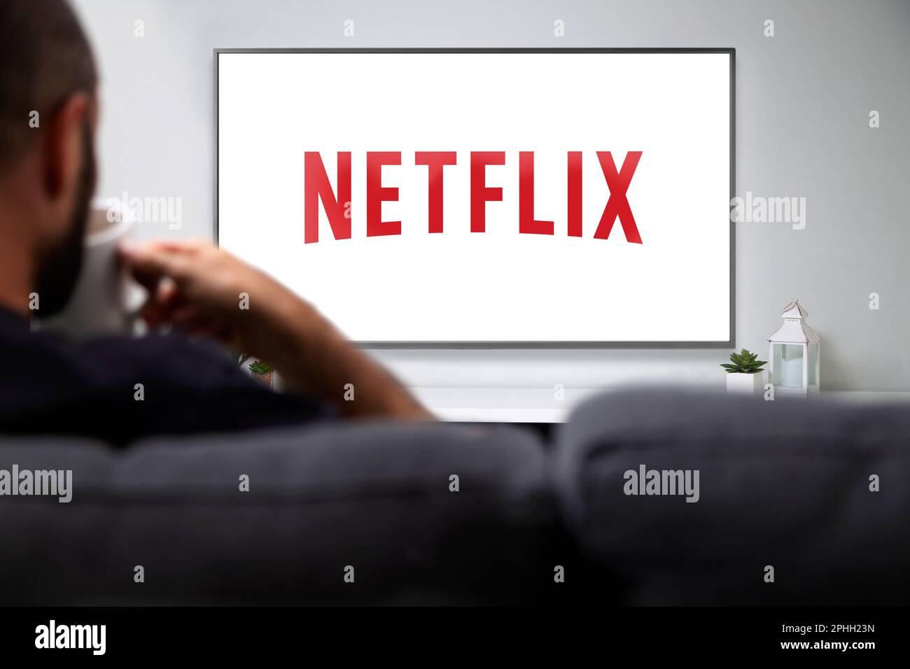 Netflix on smart TV. Man with a mug and watching television with a ...