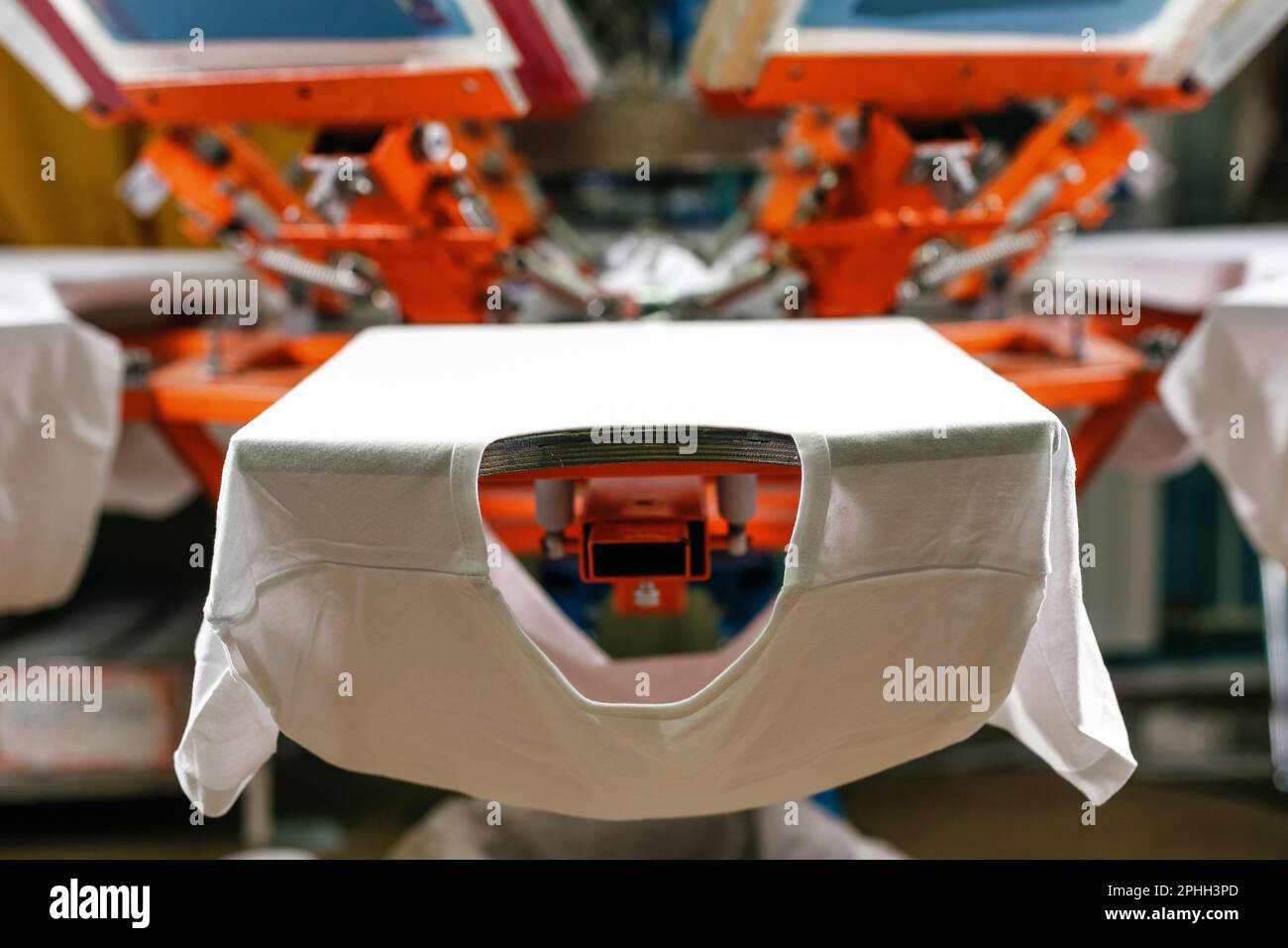 white t-shirts on a print screening apparatus. silk screen printing ...