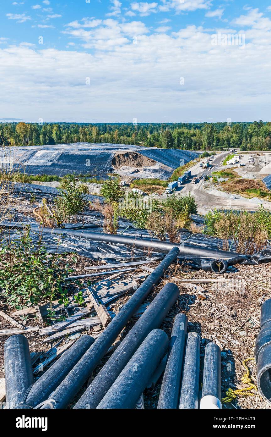 Plastic pipes litter the foreground in front of a landscape showing ...