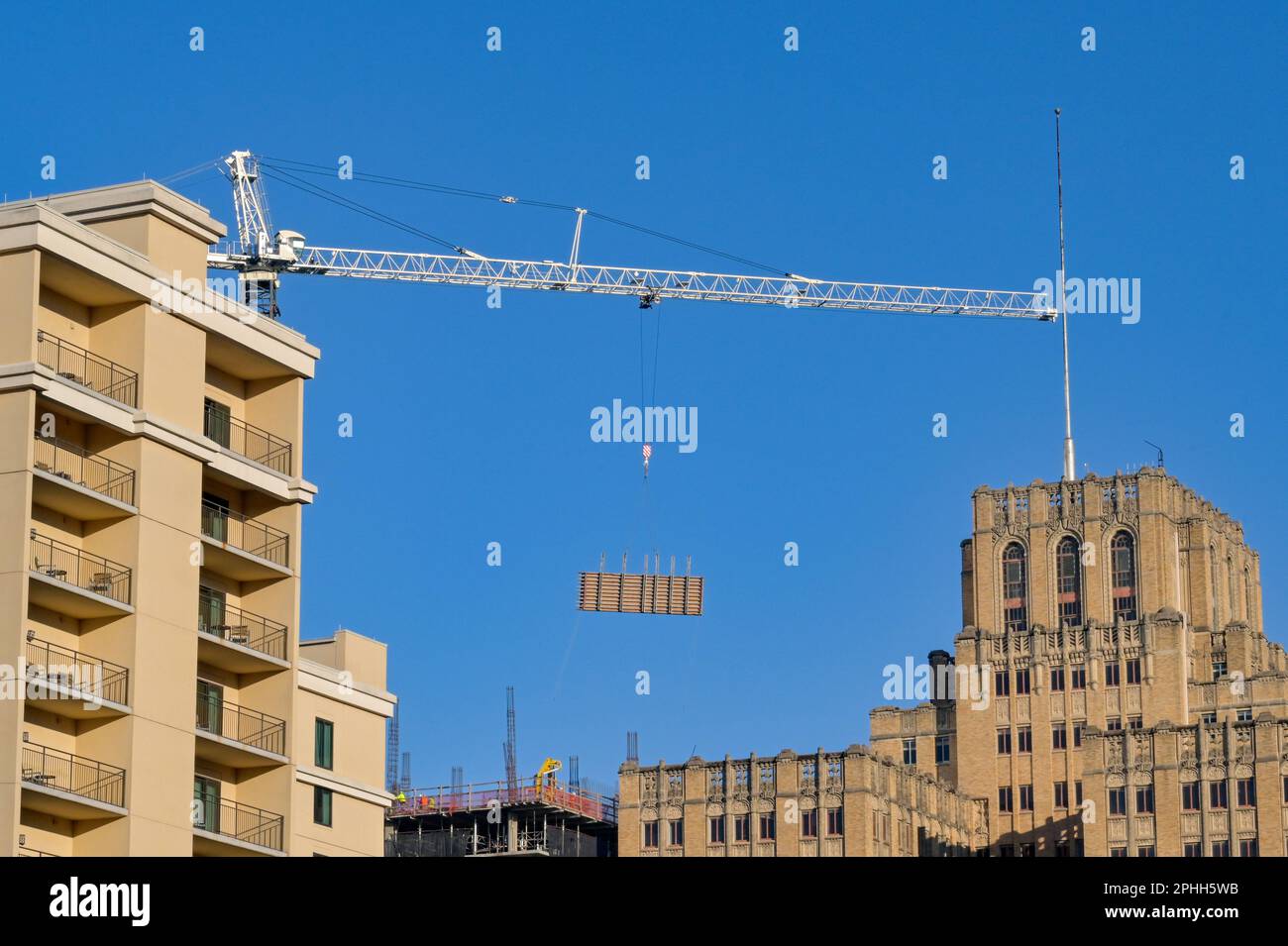Austin, Texas, USA - February 2023: Tower crane lifting a large load ...