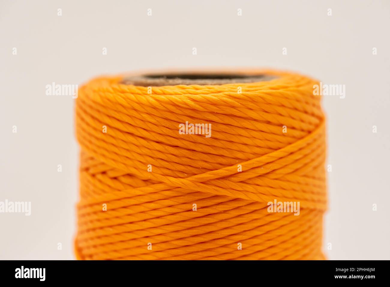 A roll of synthetic orange thread Stock Photo - Alamy
