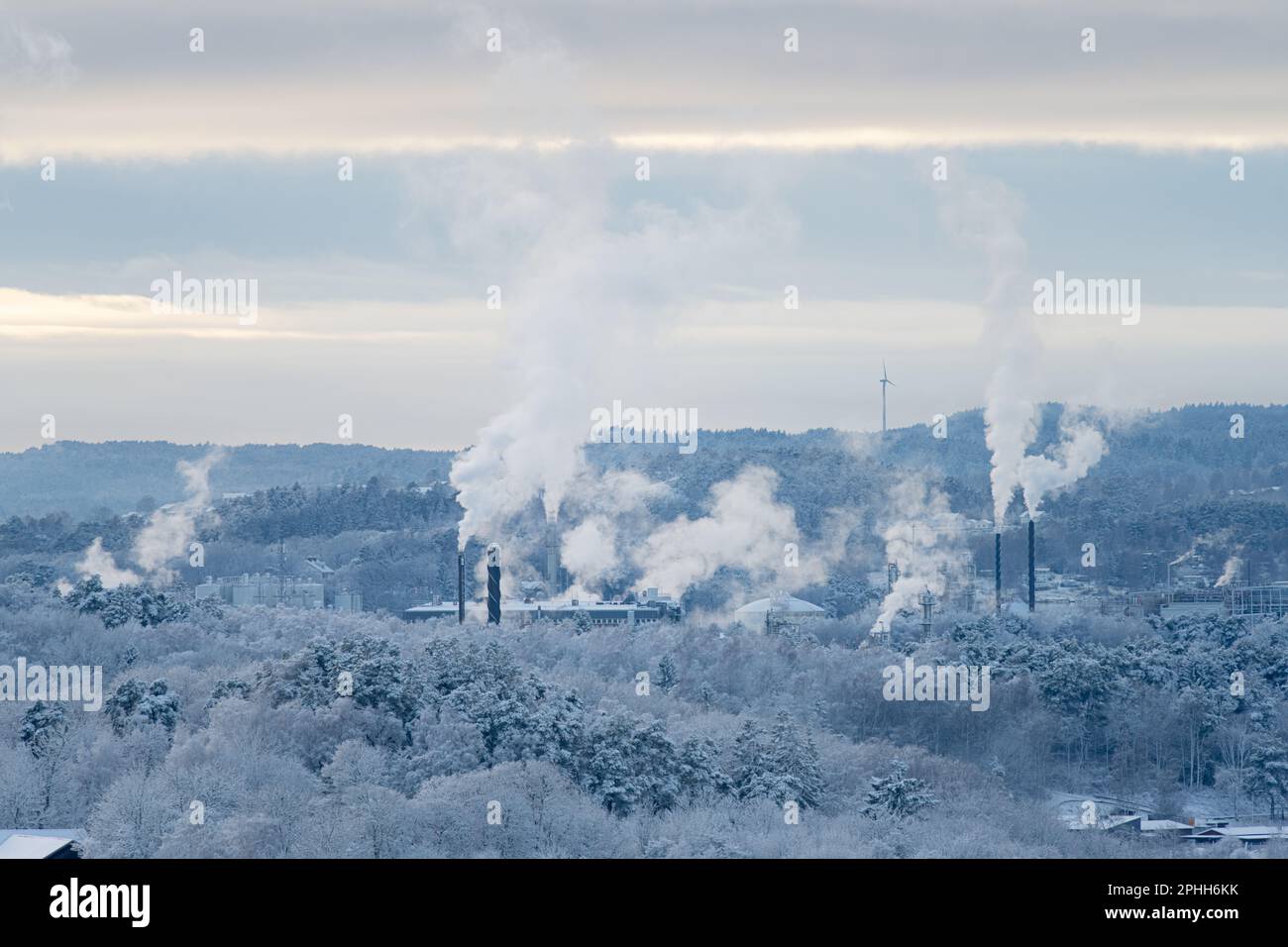 Steam rising from industrial buildings behind a snowy forest Stock ...