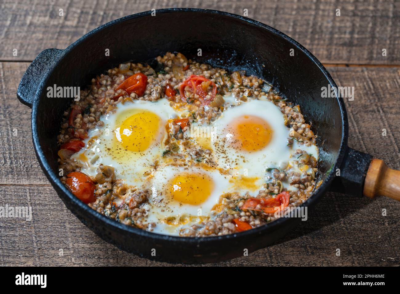 Boiled buckwheat with fried eggs, red peppers, tomato and onions, close ...