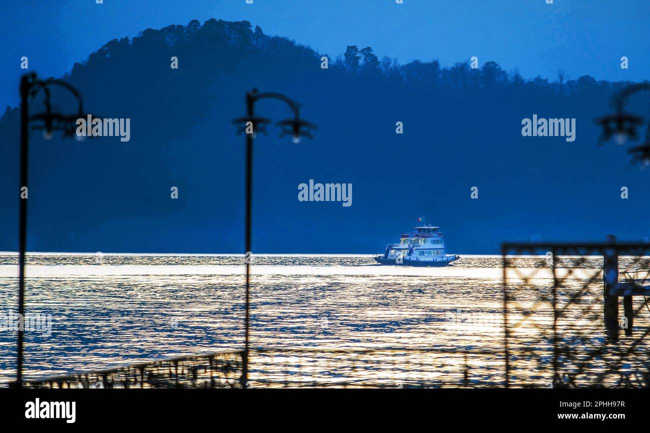 Small passenger ship sails to the town of Como Sunset on Lake Como in ...