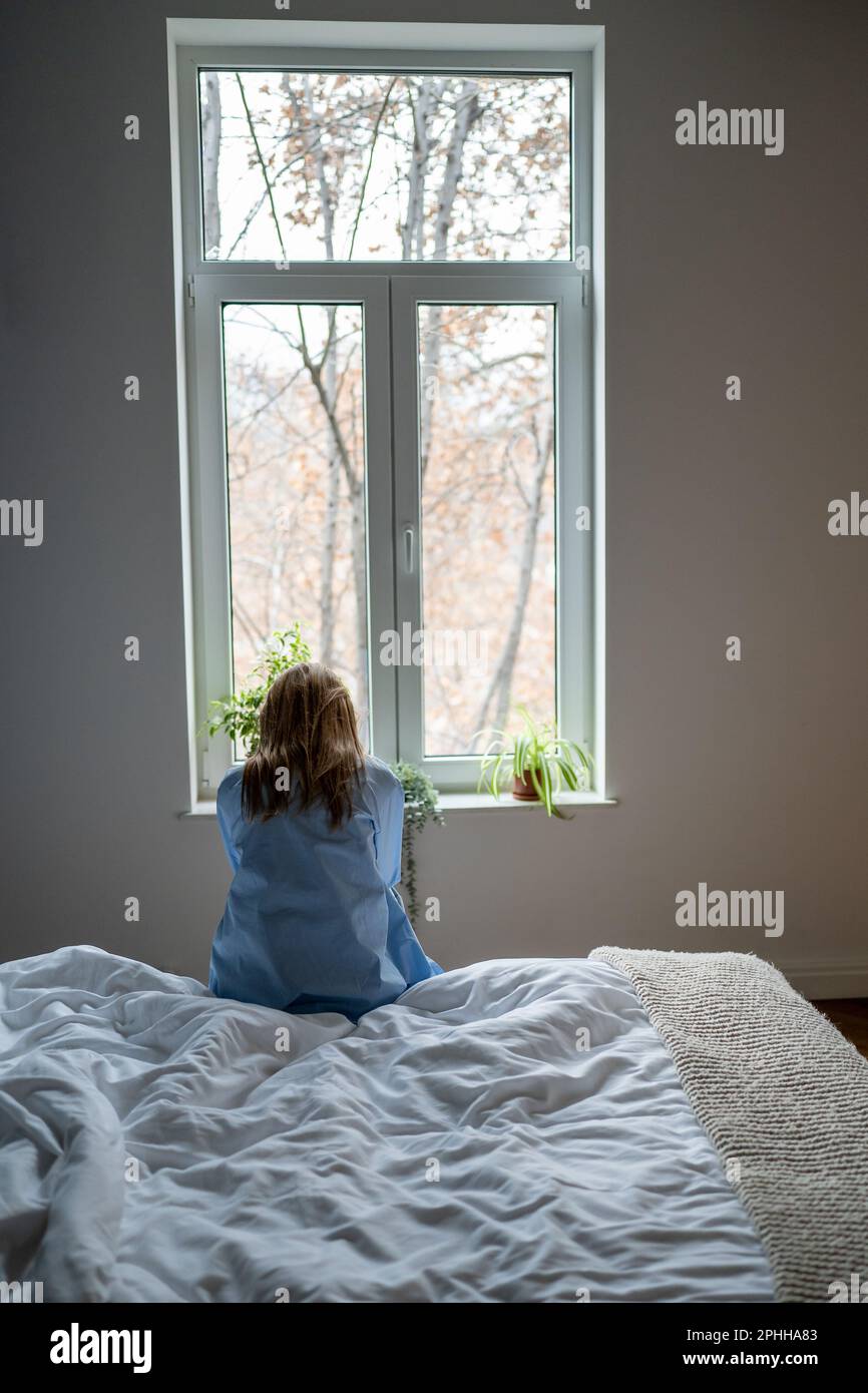 Lonely depressed woman sitting alone on bed at home Stock Photo - Alamy