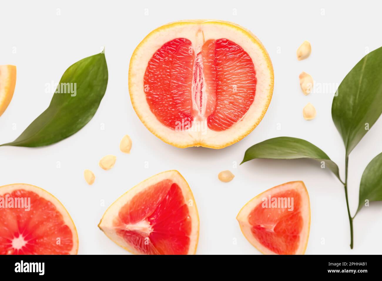 Composition with pieces of ripe grapefruit, seeds and plant leaves on ...