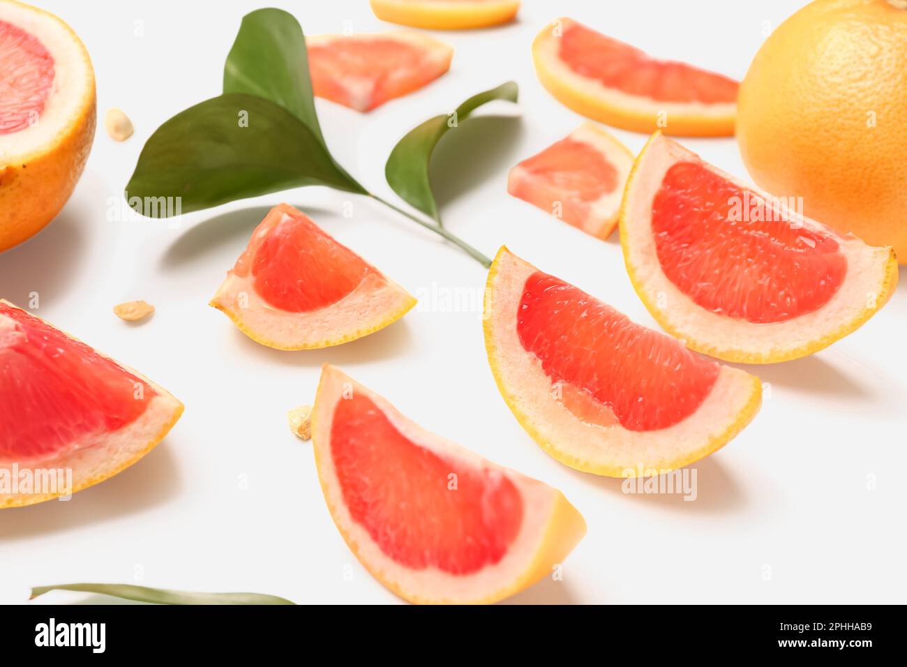 Composition with pieces of ripe grapefruit, seeds and plant leaves on ...