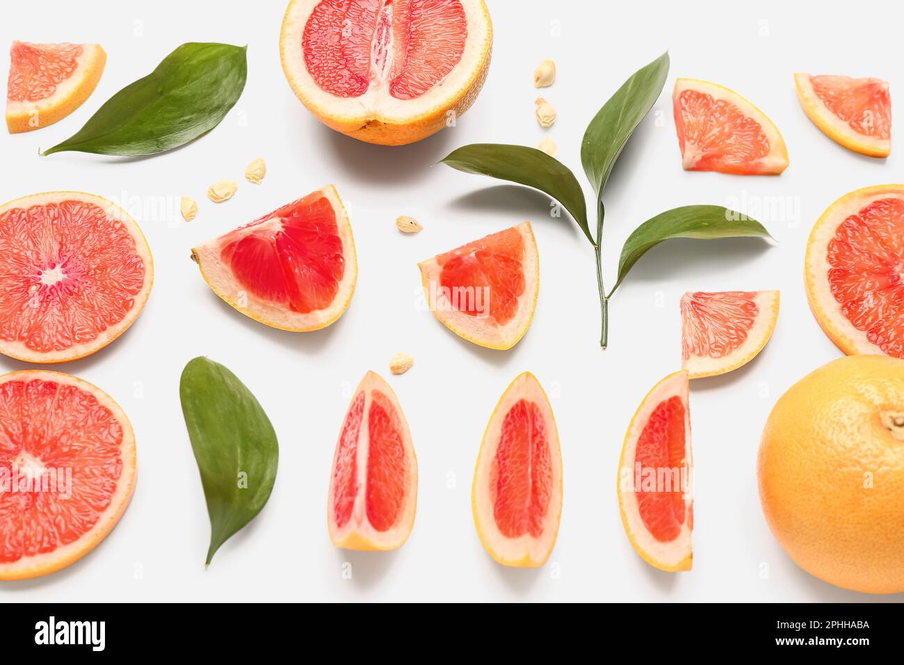 Composition with pieces of ripe grapefruit, seeds and plant leaves on ...
