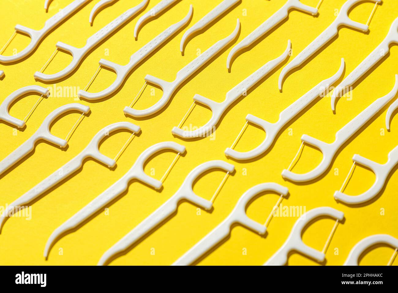 Many floss toothpicks on yellow background Stock Photo - Alamy