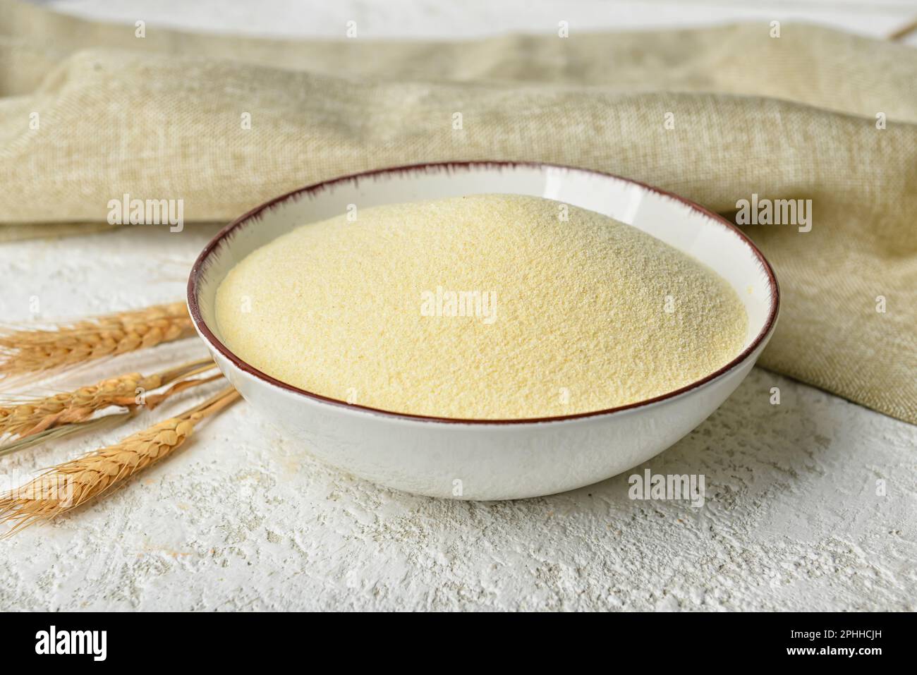 Bowl of raw semolina and spikelets on white background Stock Photo - Alamy