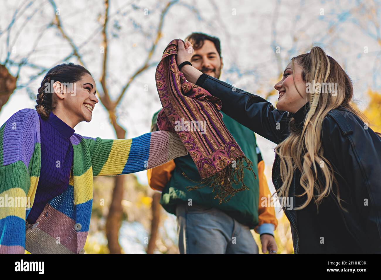Young man holding a handkerchief while two women, one blonde and one ...