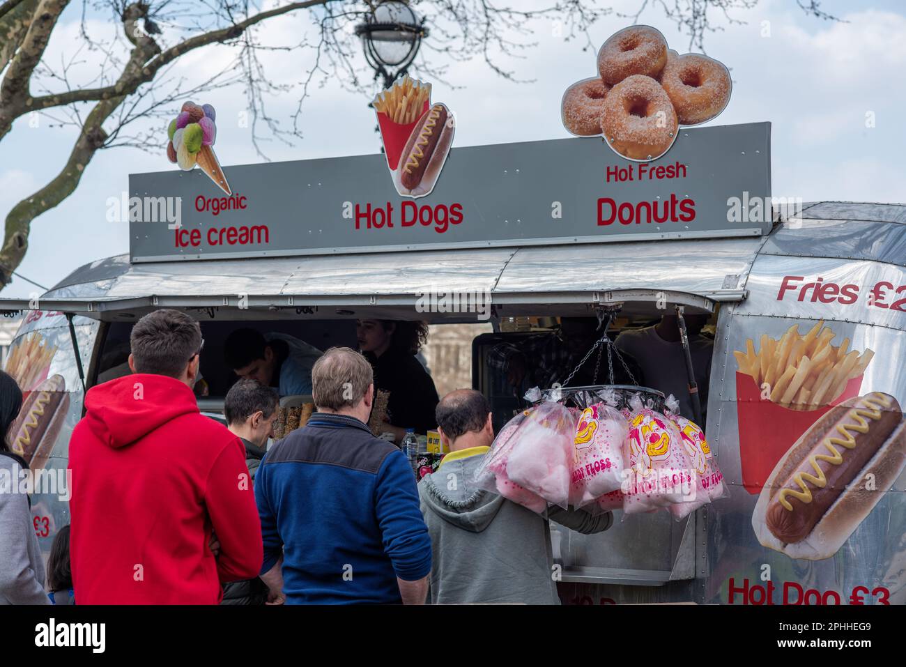 People queue up for hot dogs, donuts and ice cream, near embankment ...