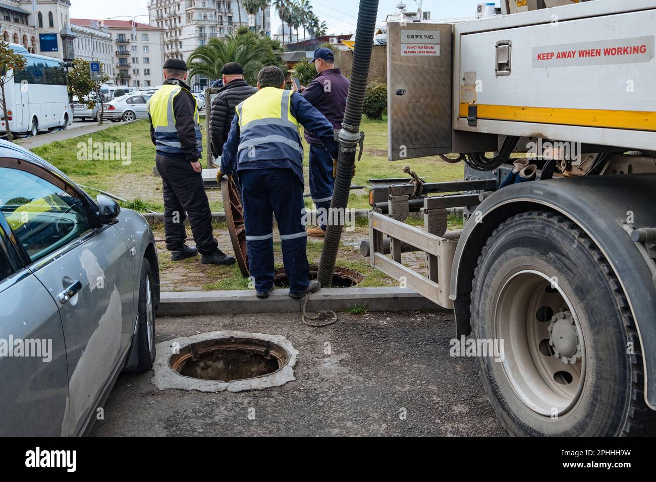 Sewer workers cleaning manhole and unblocking sewers the street ... Sewer workers cleaning manhole and unblocking sewers the street ...