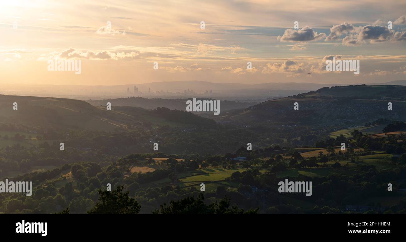 The modern towers of Manchester in the far distance surrounded by hills ...