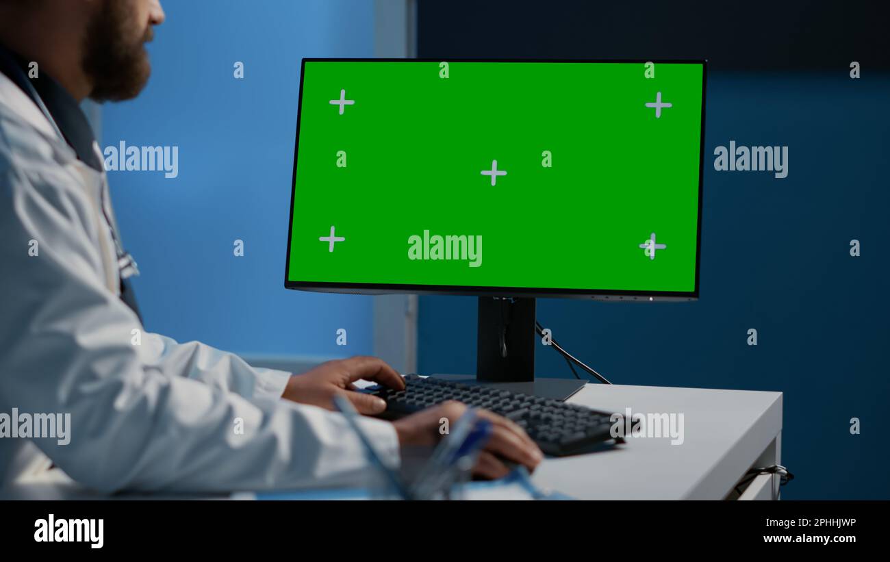 Doctor typing medical expertise on computer with green screen chroma ...