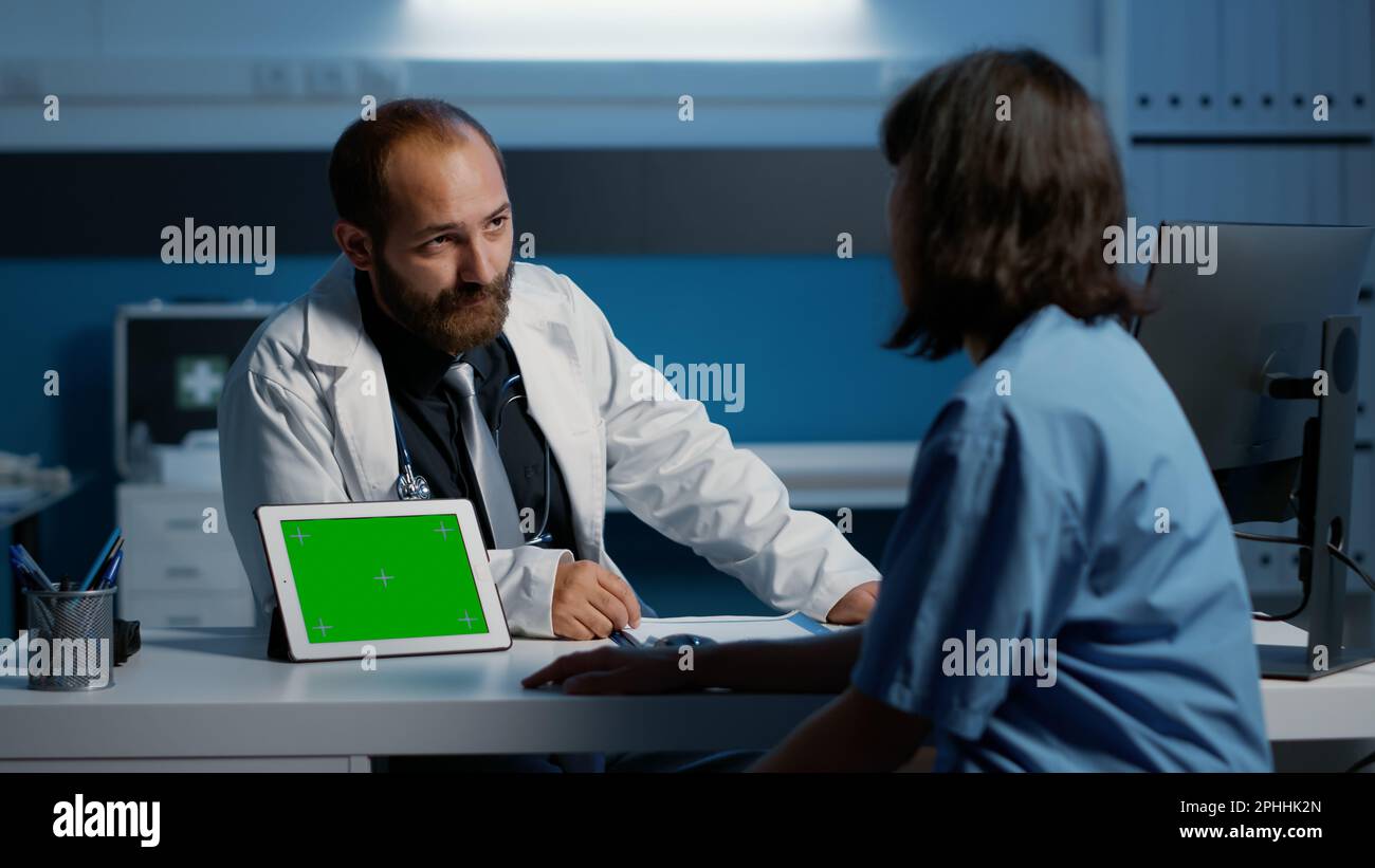 Medical staff working late at night in hospital office discussing ...