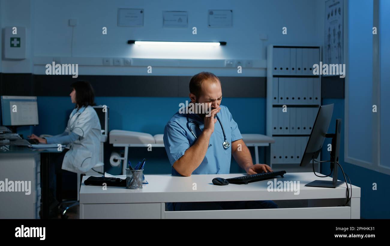 Tired exhausted physician assistant typing medical expertise on ...