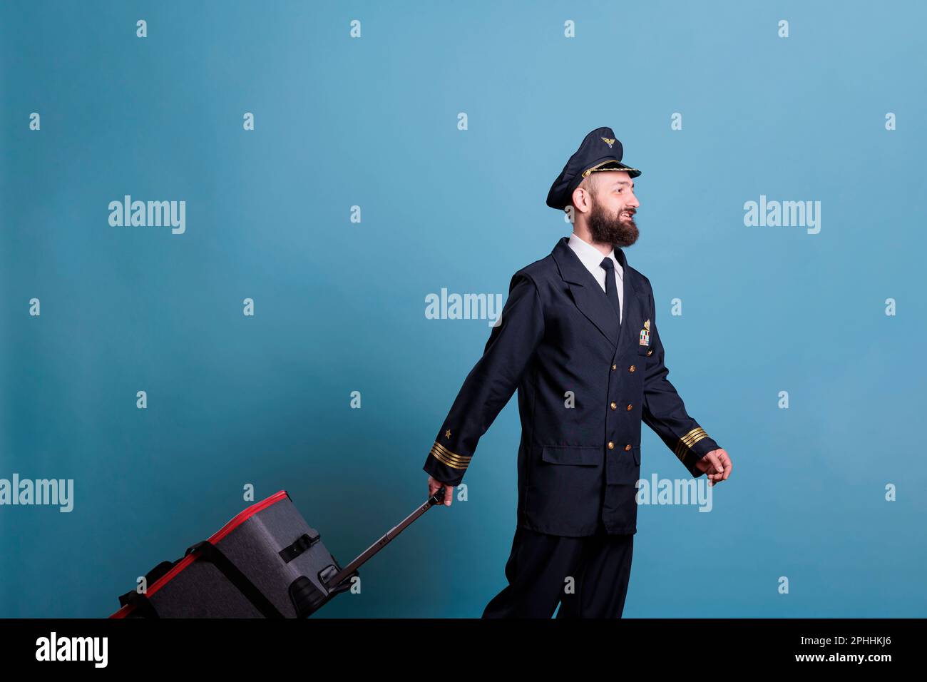Airplane captain in professional airline uniform walking with suitcase ...
