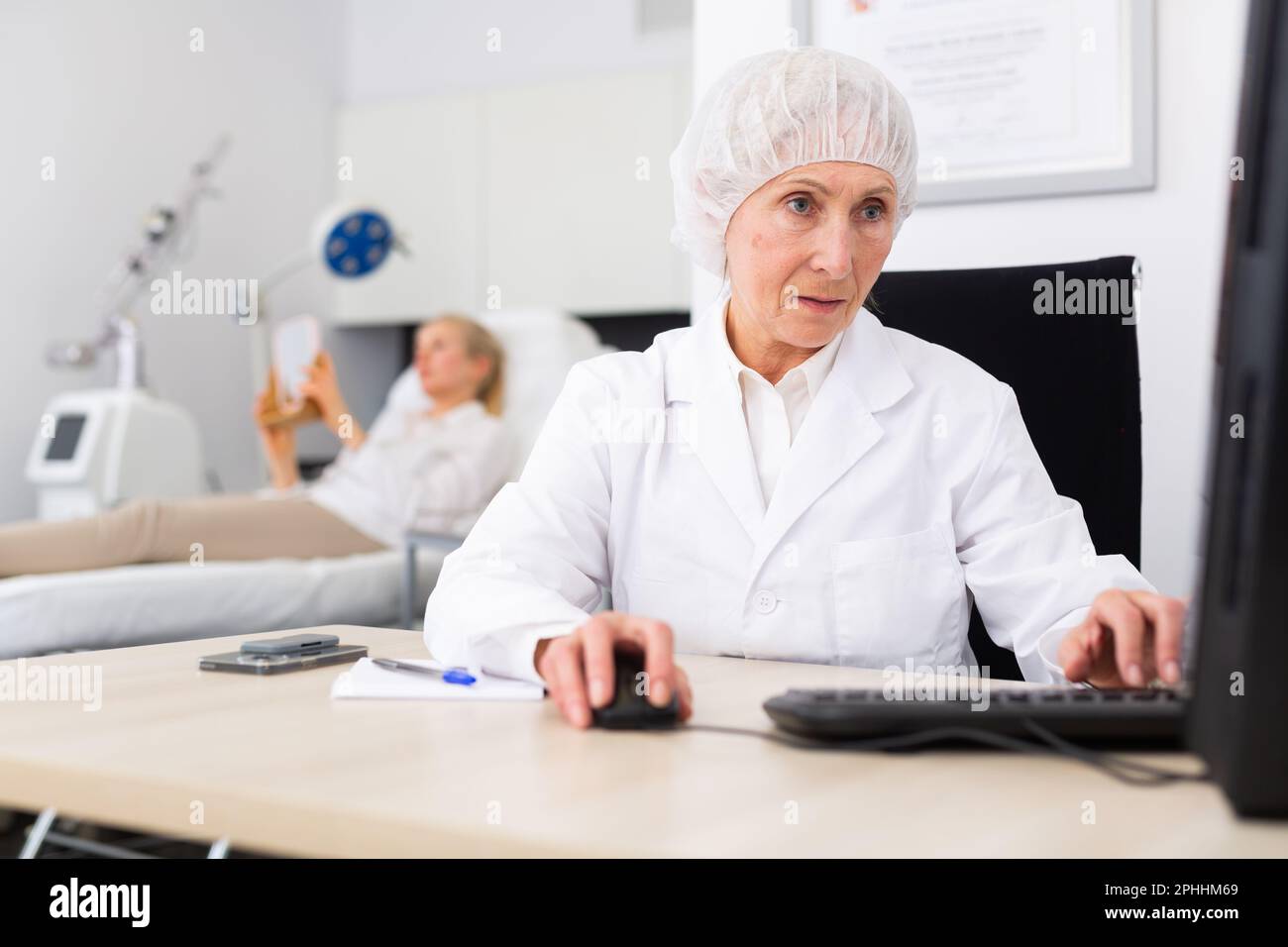 Senior woman dermatologist using computer during appointment Stock ...
