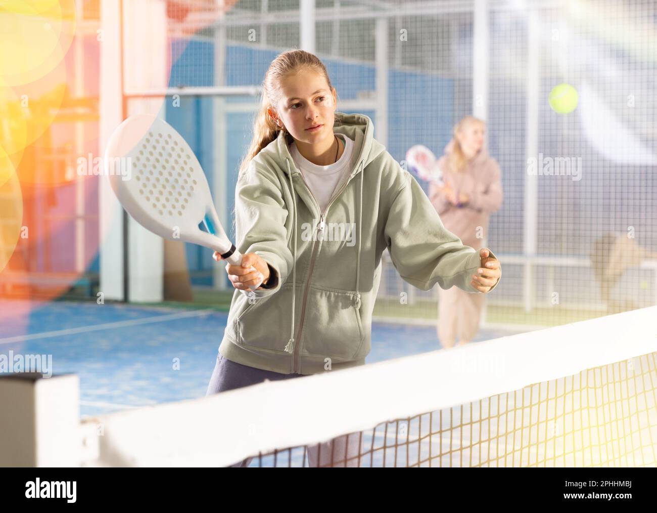Teenage girl playing padel in court Stock Photo - Alamy