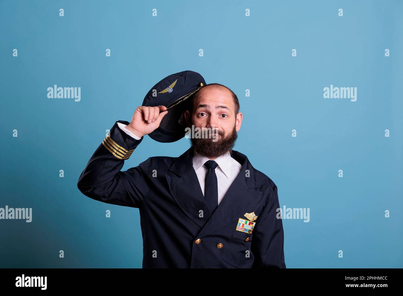 Airplane pilot taking hat off, looking at camera with confused facial ...