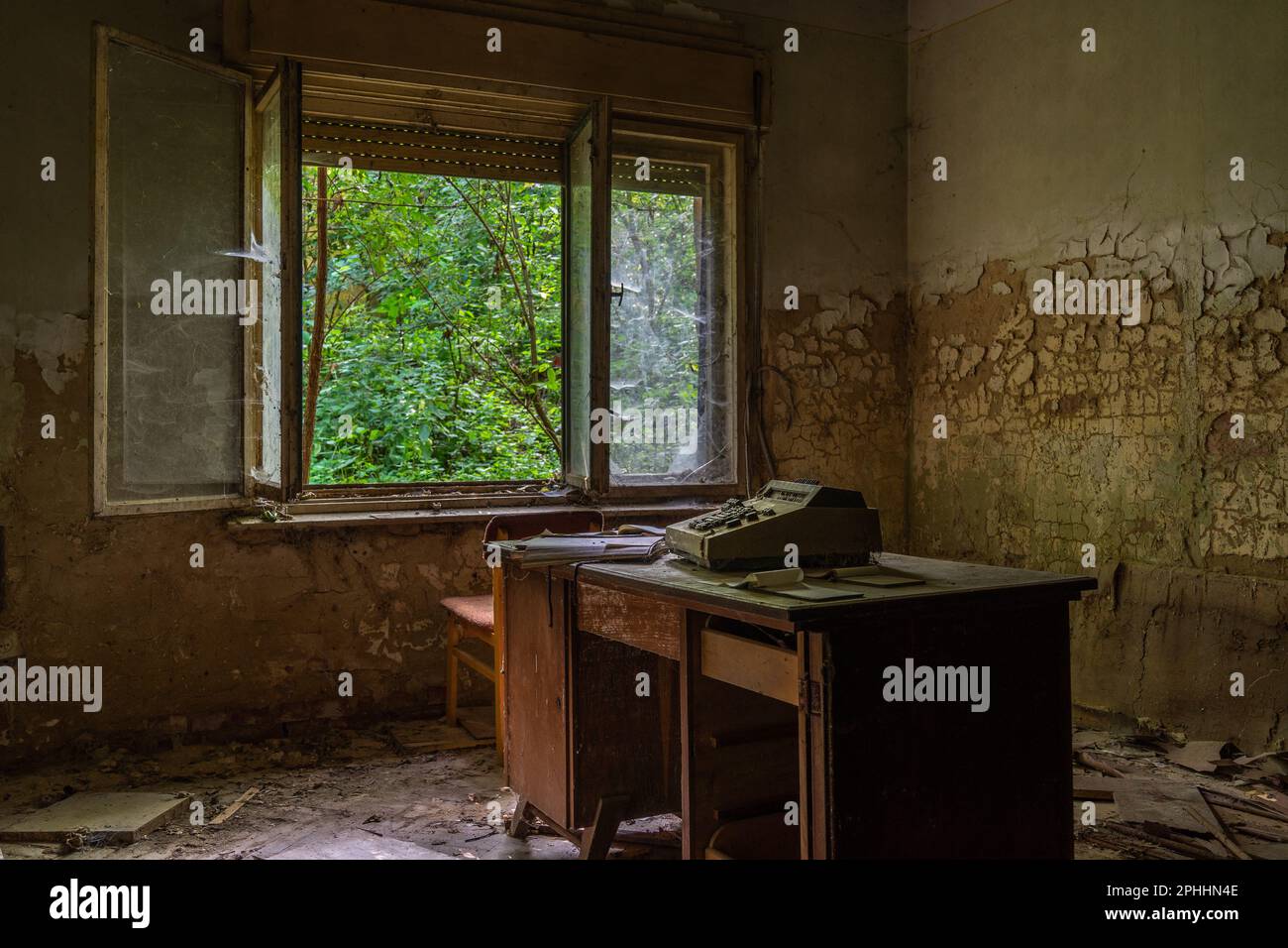 Old typewriter on a wooden desk in a ruined and abandoned room, with a ...