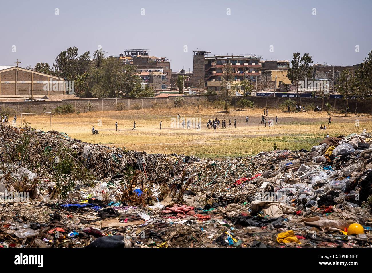 View of a school behind the waste mountains of Dandora dumpsite ...