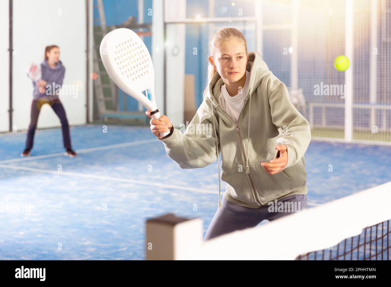Padel game - teen girl actively kicks ball during a padel game Stock ...